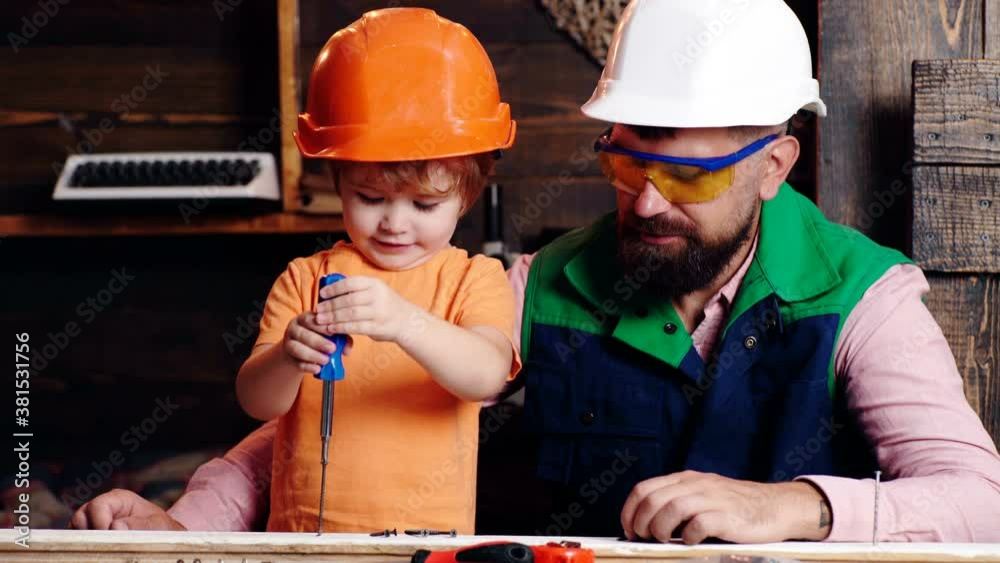 Construction of father and son in the garage. Little son helping his ...