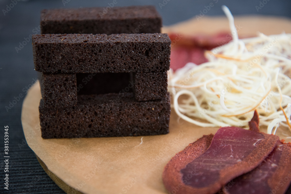 On the paper is smoked sausage and cheese in small threads. Close-up ...