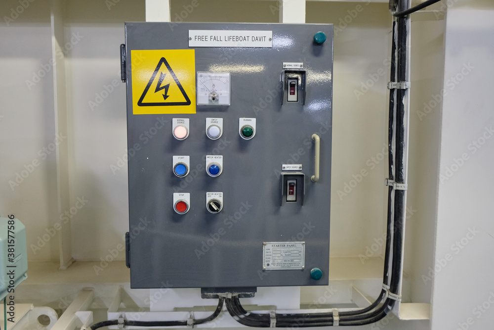 Freefall lifeboat davit control panel with high voltage sign on bulk ...