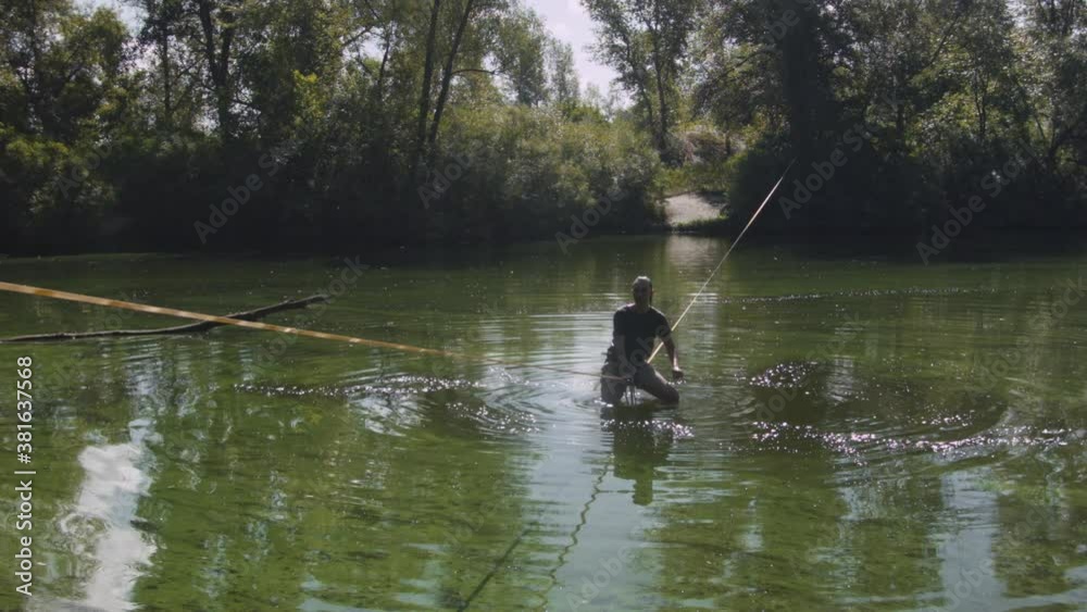 Caucasian man practicing slackline over the surface of the river in the ...
