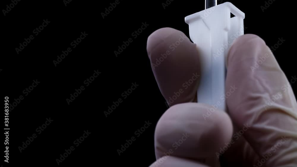A doctor adjusts a medical drip valve in the light of a ambulance car ...