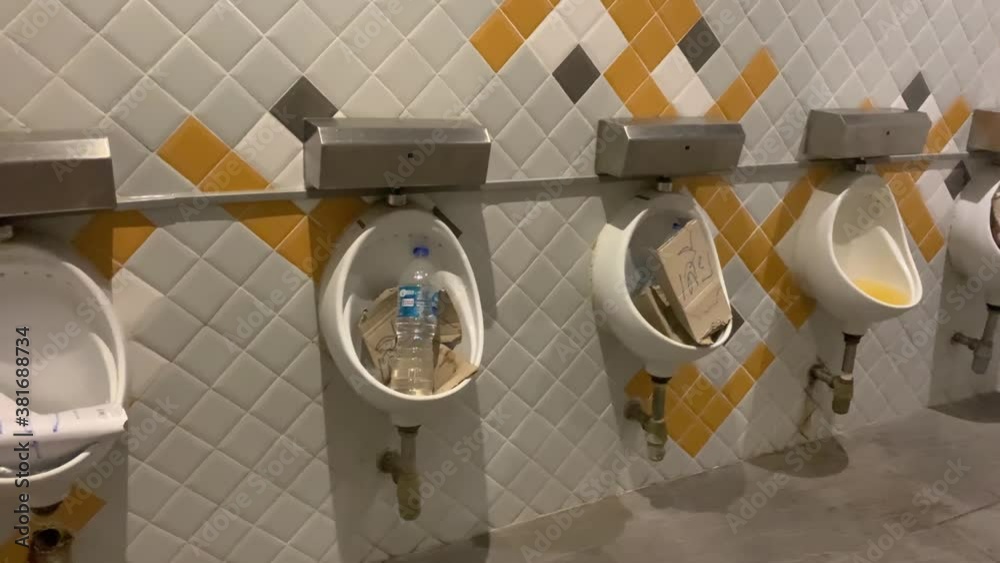 Inside a neglected dirty disgusting smelly public restroom - wide pan ...