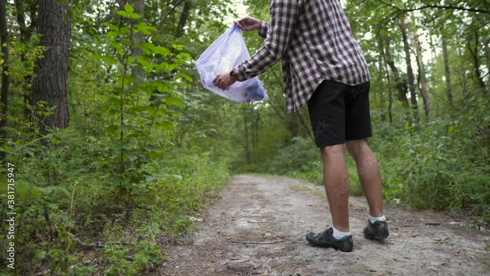 Young man throwing litter garbage from plastic bag on ground ...