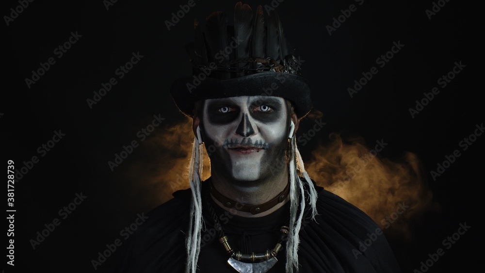 Scary guy in costume of Halloween skeleton wearing earphones, listening ...