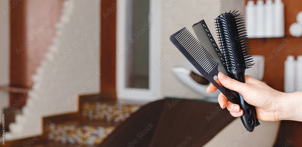 Combs for hair cut in female hairdresser hand against hair wash sink ...