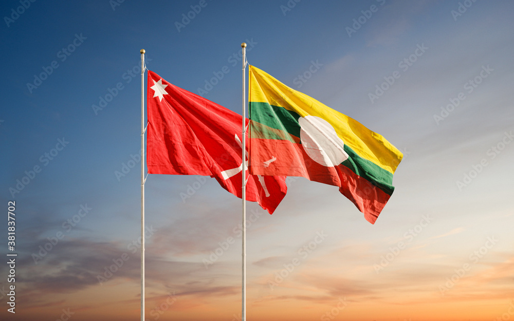 Waving flags of Shan State and Shan State Army South against sunset sky ...
