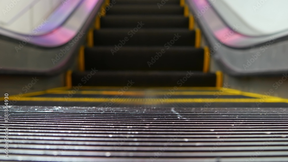 Low angle looped perspective view of modern escalator stairs. Automated ...