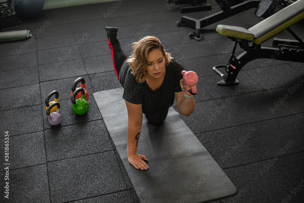 Fat woman fights overweight in the gym, doing heavy fitness exercises ...