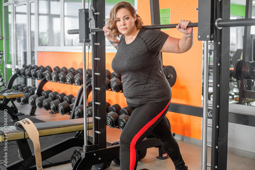 Fat woman fights overweight in the gym, doing heavy fitness exercises ...
