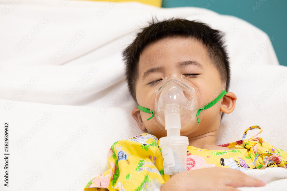 Asian little boy making inhalation with nebulizer at hospital ...