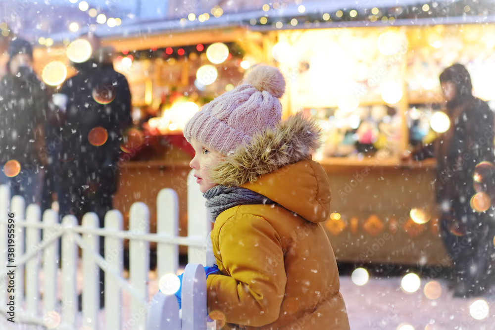 Little boy having fun with his family on traditional Christmas fair ...