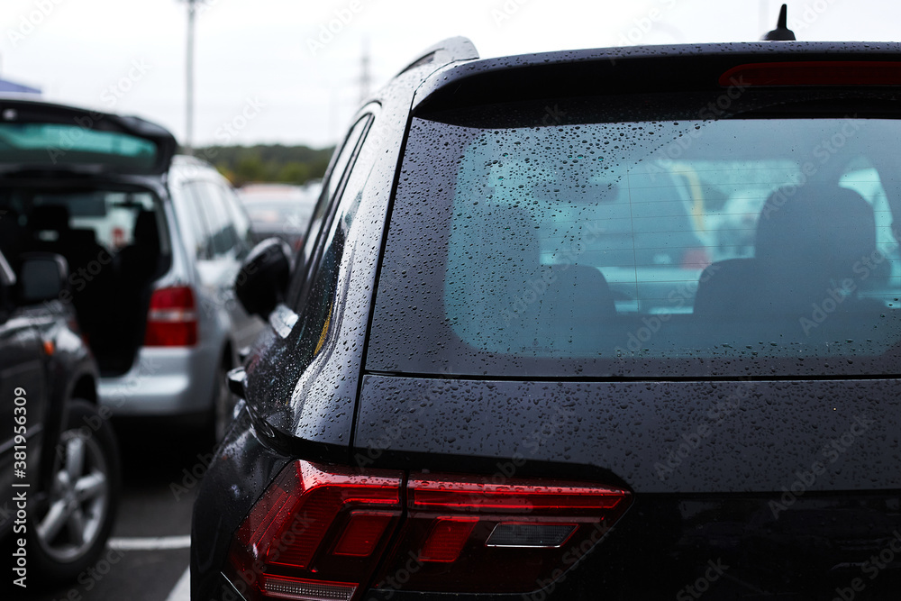 Back window of dark car parked on the street in autumn rainy day, rear ...