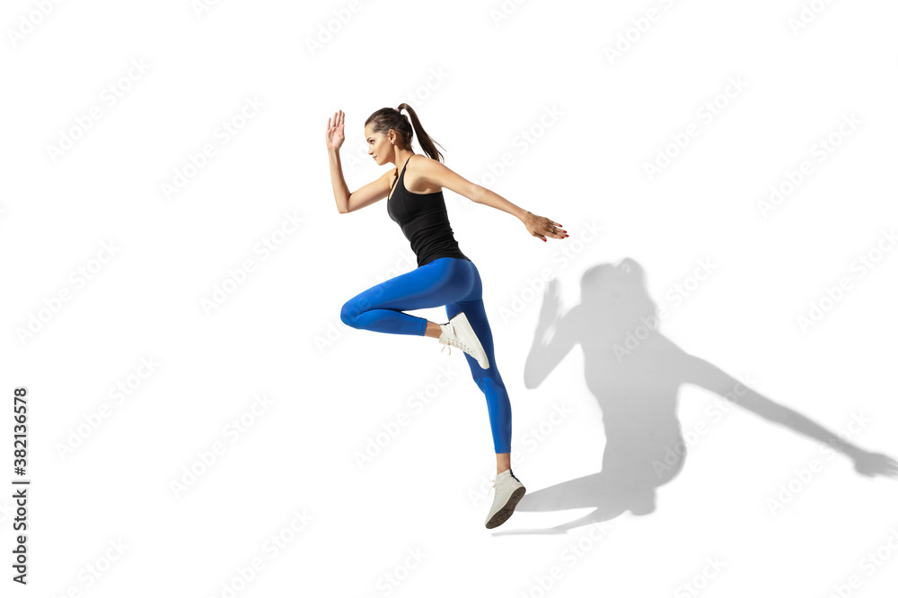 High jump. Beautiful young female athlete stretching, training on white ...