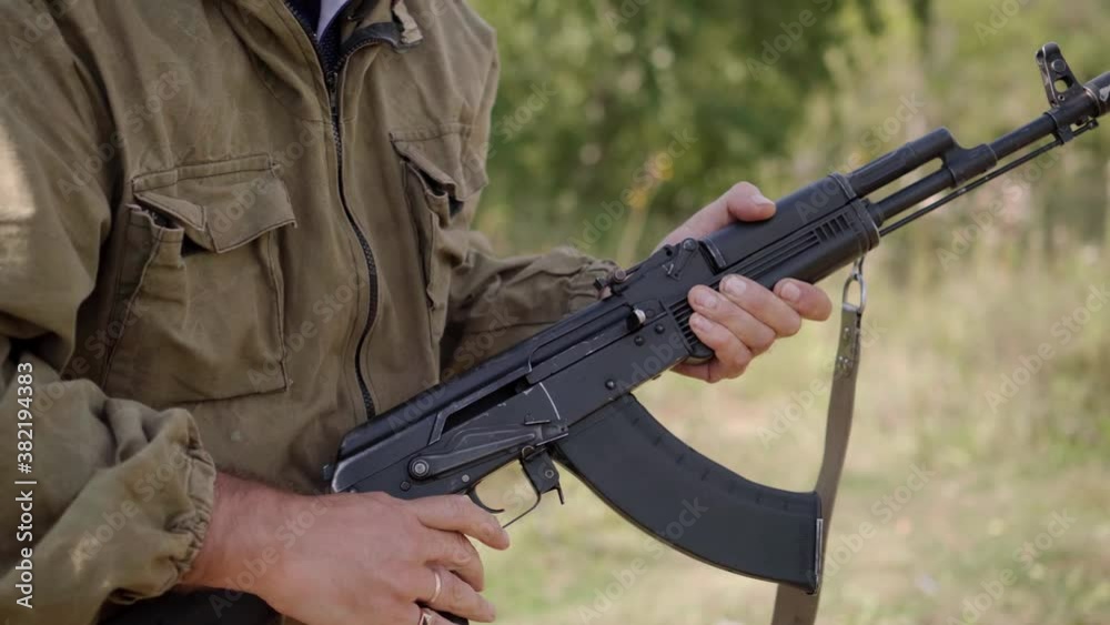 Armed man loading firearm, removes the fuse and reloads the cartridge ...