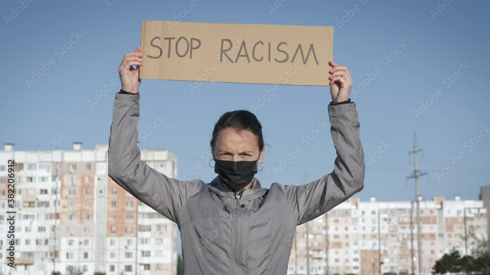 Discrimination about skin. A woman in medical mask hold a cardboard ...