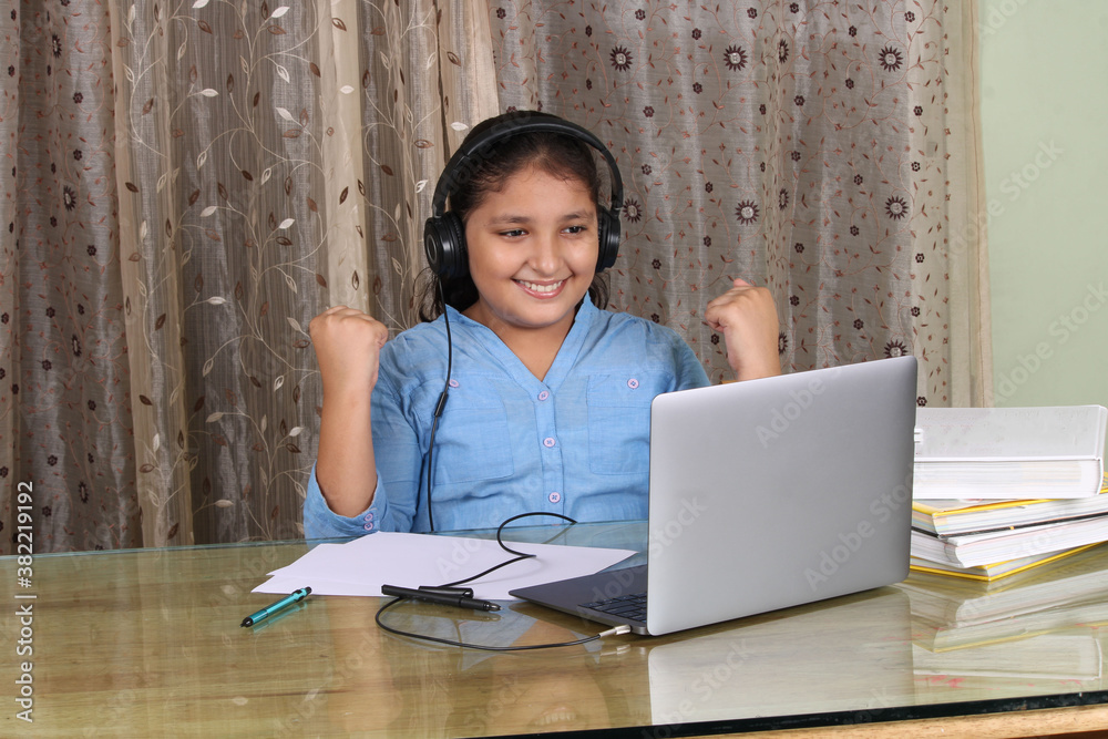 Young Indian girl wearing headset learning through laptop. E- learing ...