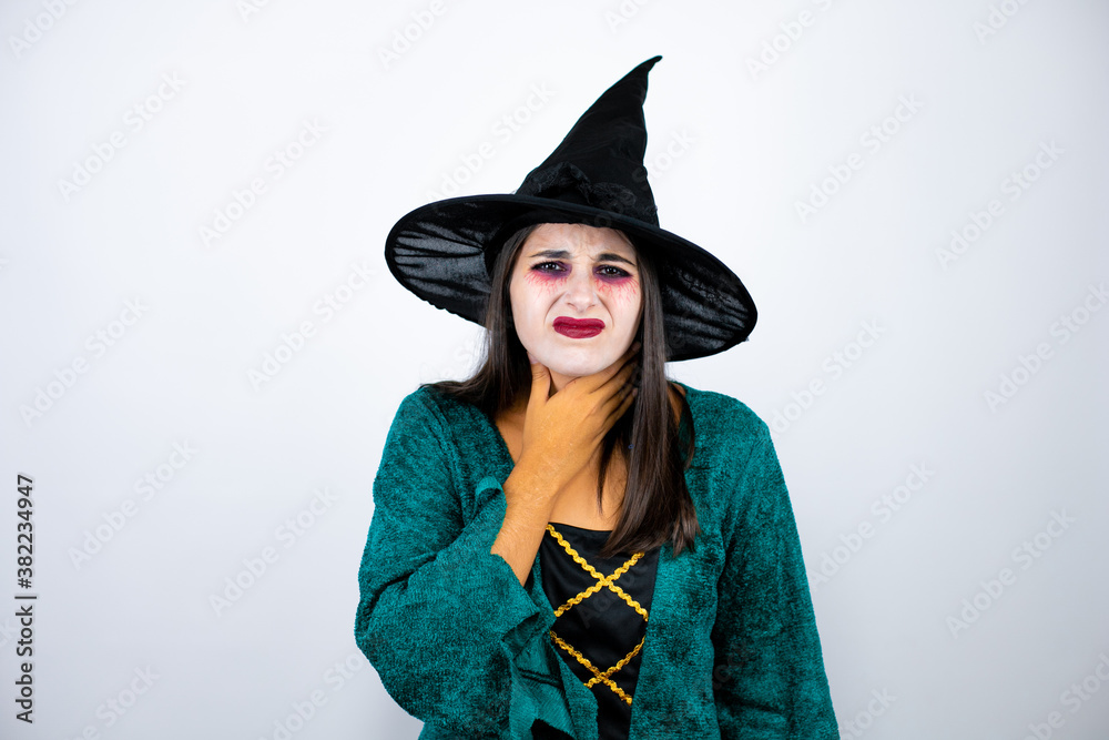 Woman wearing witch costume over isolated white background touching ...
