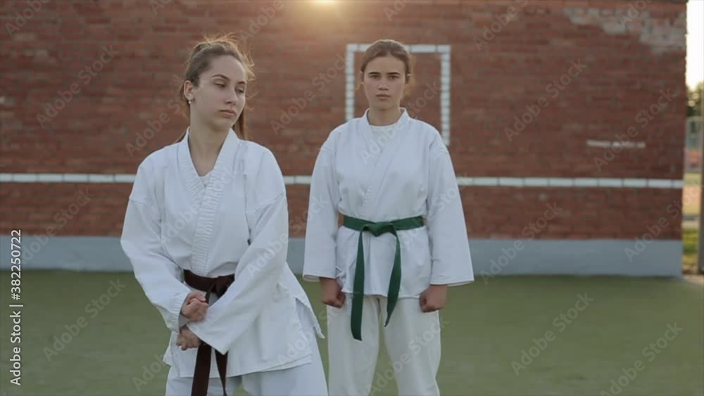 Stockvideon Young girls in white kimonos bow and show different karate ...