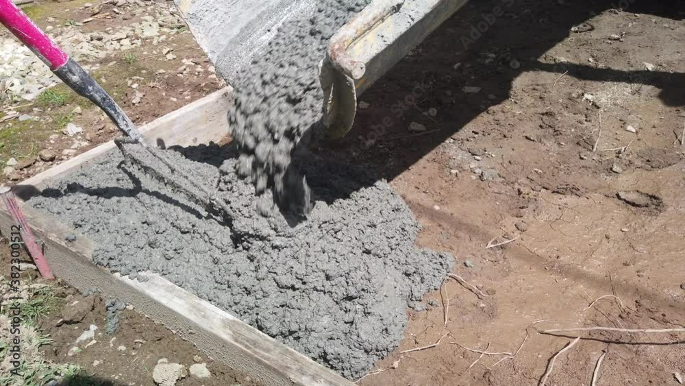 Truck pours wet mushy heavy concrete through chute in corners and side ...