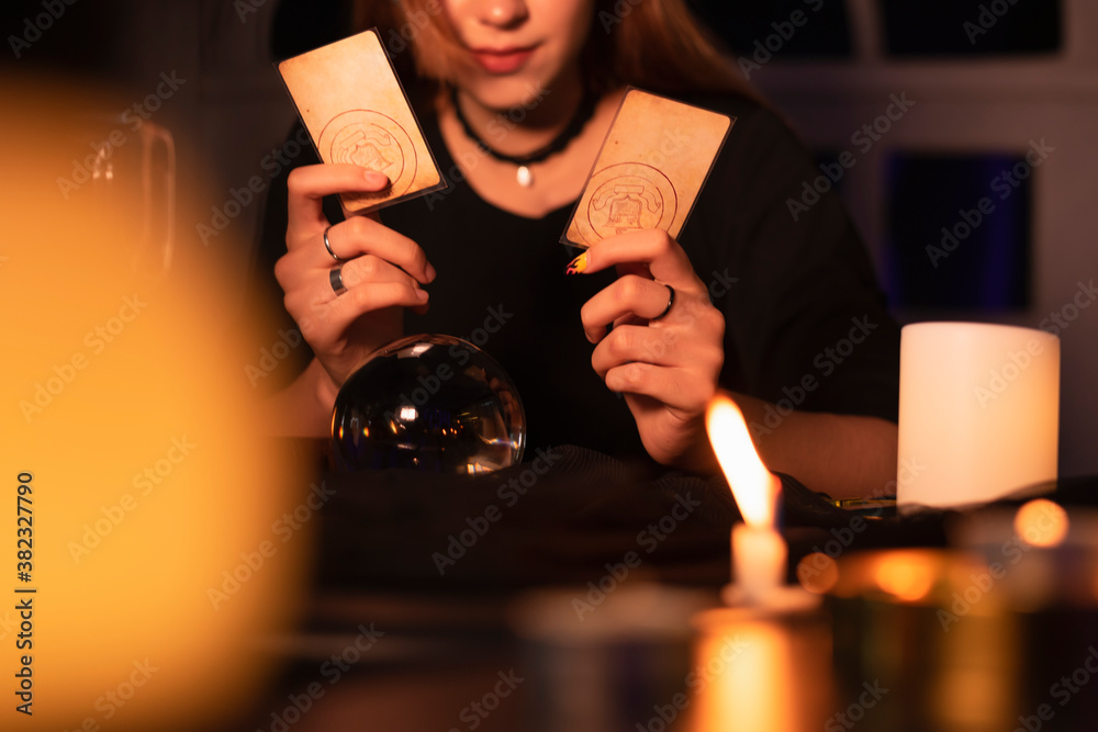 Beautiful young woman fortune teller using tarot card to predict the ...