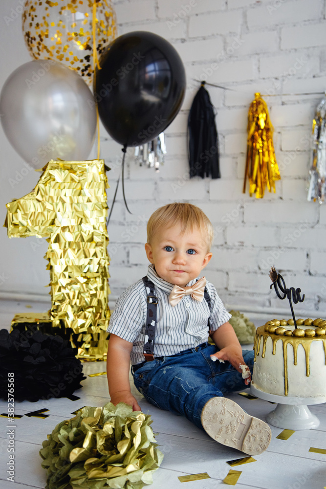 Boy blond 1 year on his birthday. Decorated photo zone with the first ...