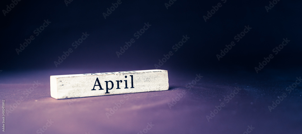 April, name of the month written on vintage white wooden block on ...