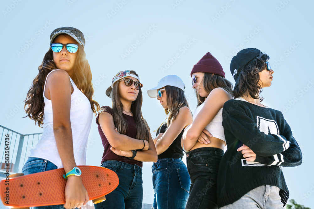 Five girls posing with a skateboard. Stock Photo | Adobe Stock