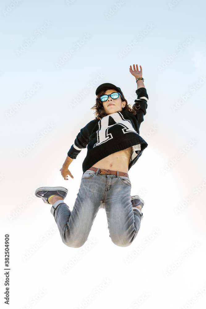 Young girl striking a pose while jumping Stock Photo | Adobe Stock