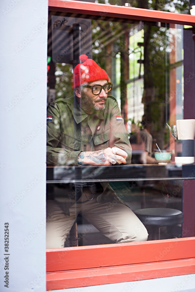 Trendy / cool middle aged man in window of cafe / street style in ...
