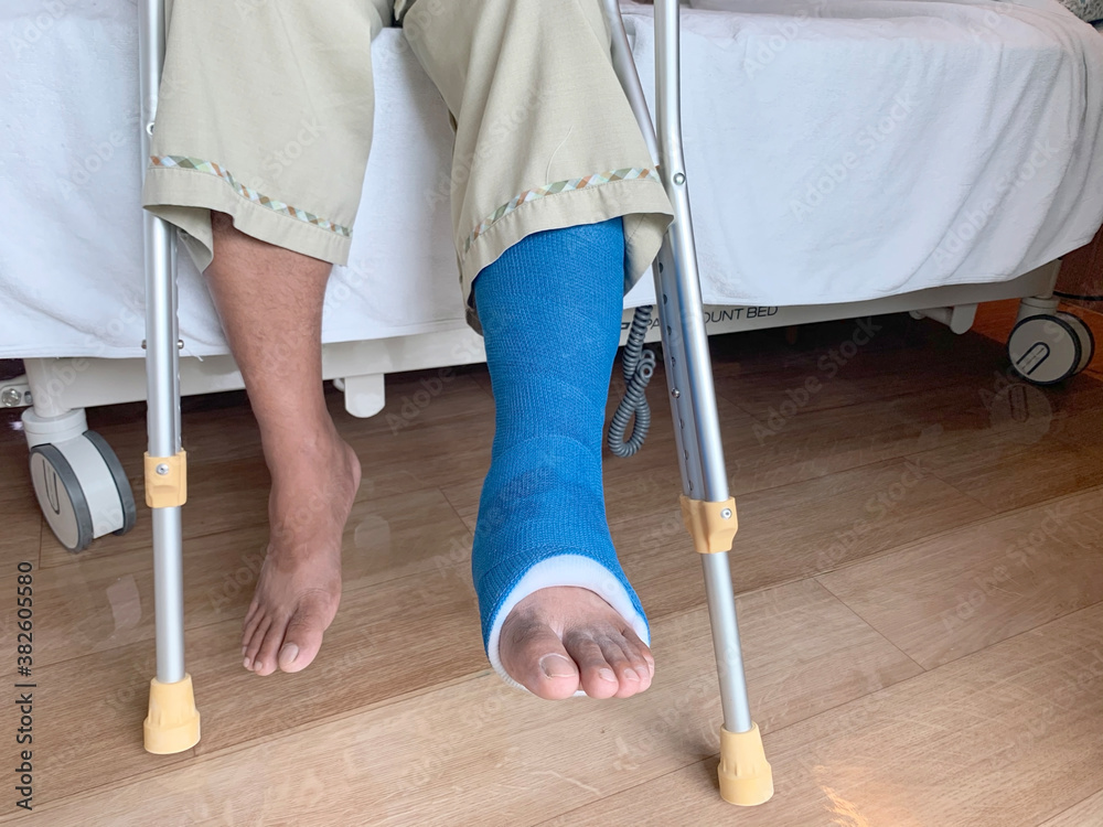 Disabled Injured Person With Sprained or Broken Ankle or Foot holding ...