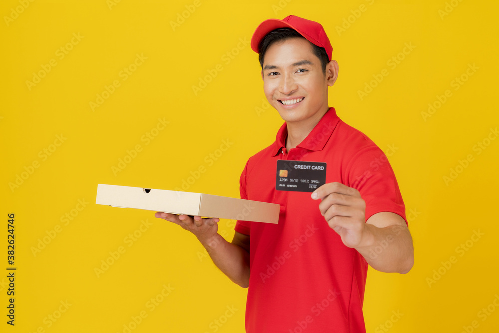 Smiling delivery man employee in red cap blank t-shirt uniform standing ...