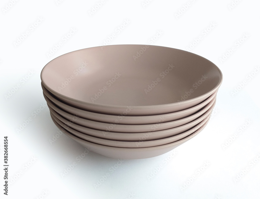 Set of stacked ceramic soup plates isolated on white background. Empty ...