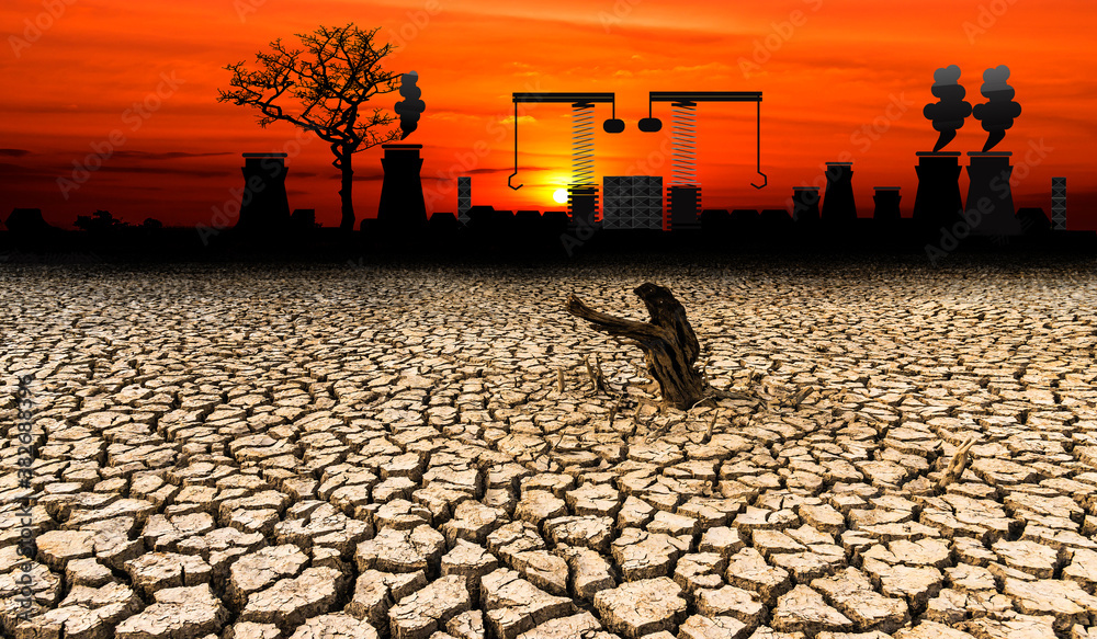 silhouette of a large industrial factory on orange sunset background ...