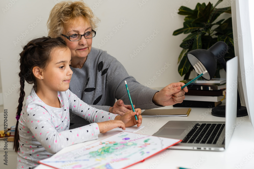 Cute and happy little girl child using laptop computer with her grandma ...