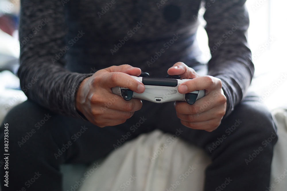 persona jugando videojuegos, manos sosteniendo un control de ...