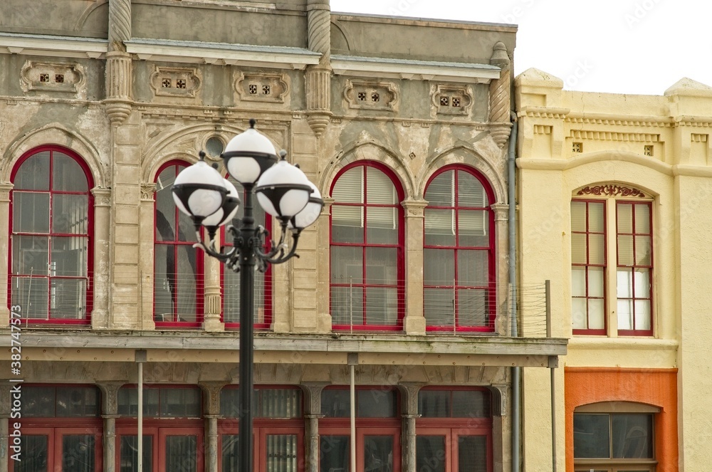Historic street light and buildings with tall, red framed windows ...