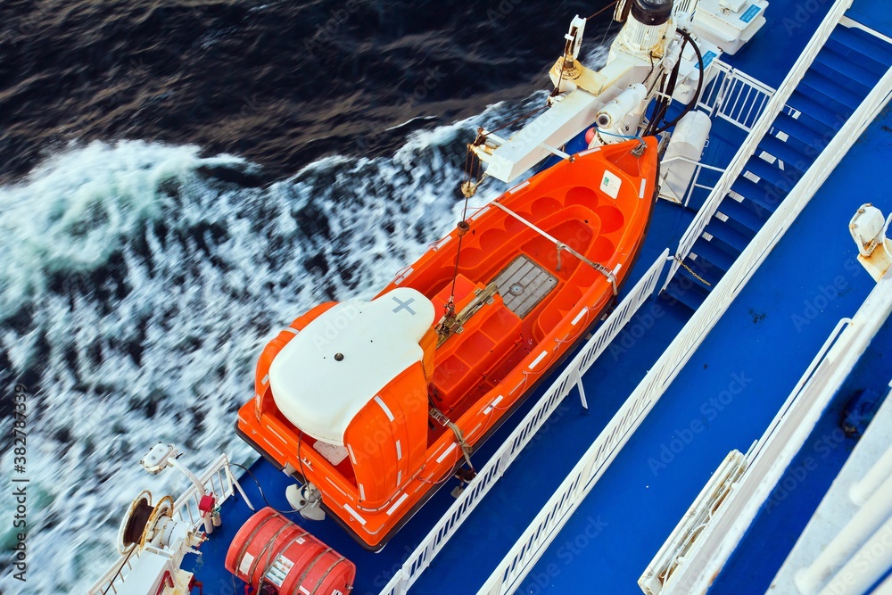 A top view on orange lifeboat on the deck of a ship sailing in the ...