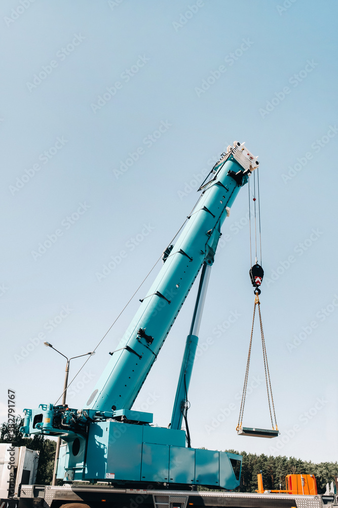 the stove is loaded onto a large blue car crane and prepared for ...