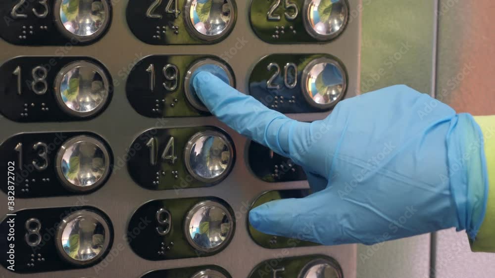Hand in rubber glove push the elevator or lift button. Personal ...