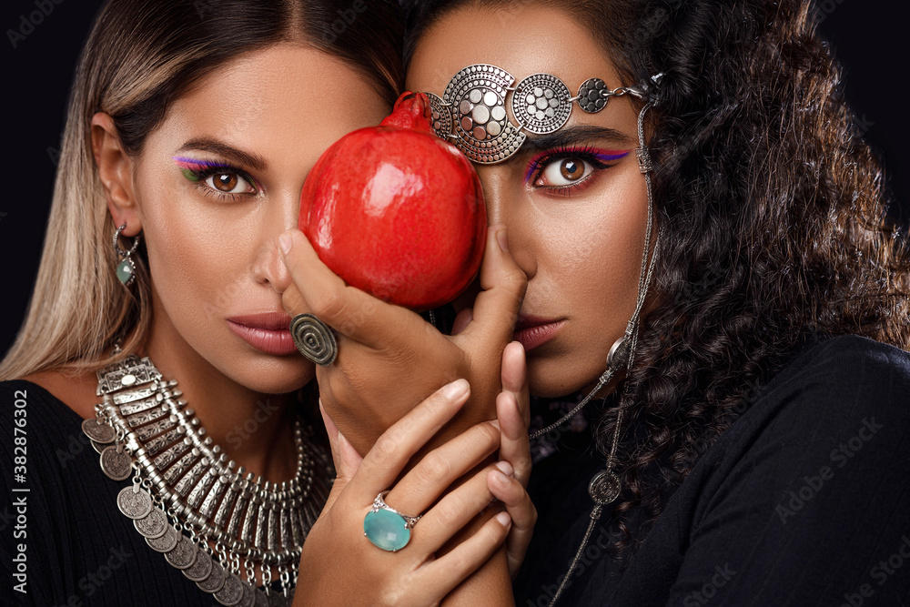 A studio portrait of two young women with national makeup matching the ...