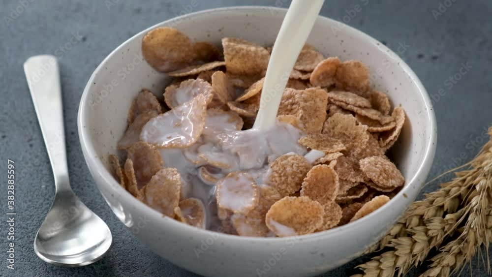 Vidéo Stock Whole grain flakes with milk. Slow motion of milk pouring ...