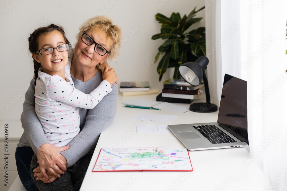 Cute and happy little girl child using laptop computer with her grandma ...