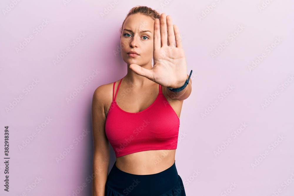 Beautiful caucasian woman wearing sportswear doing stop sing with palm ...
