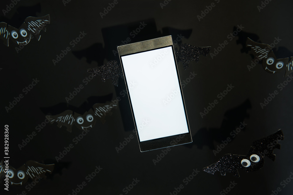 Close up flying smartphone with a blank white screen decorated with bat ...