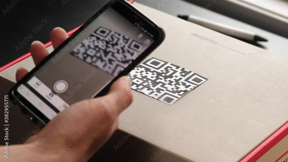 Scanning the QR code on a cardboard box with a mobile phone camera ...