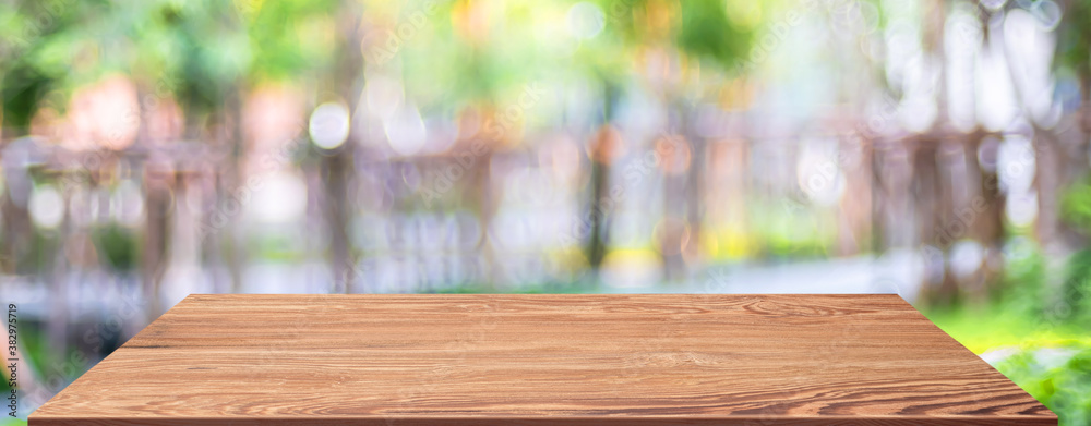 spring background.Empty brown wooden table with blur tropical tree in ...