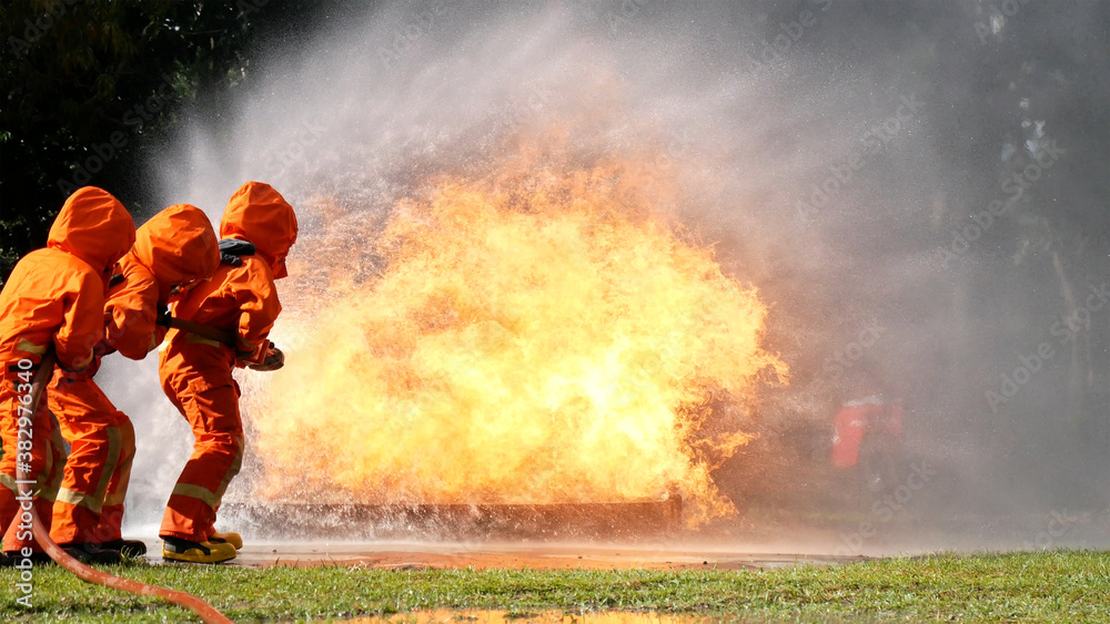 Firefighter fighting with flame using fire hose chemical water foam ...