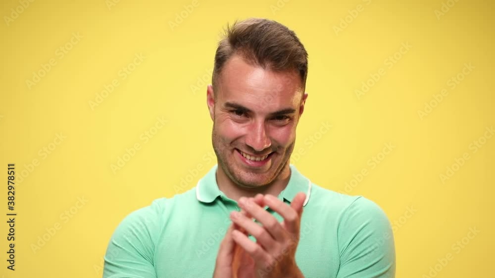 handsome young casual man clapping hands, giving a thumbs up, pointing ...