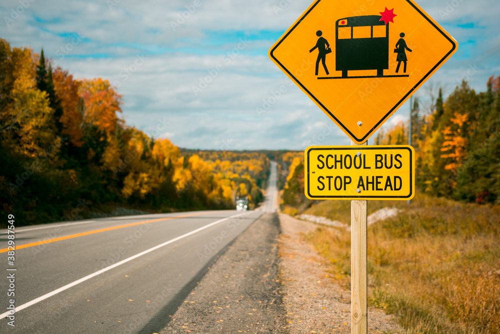 School bus stop ahead road sign. Yellow warning sign on the roadside ...