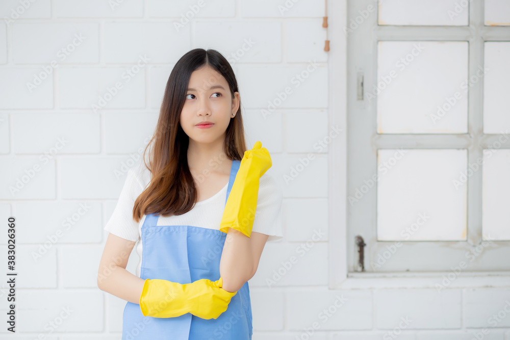 Portrait young asian woman is housekeeper in rubber gloves and apron ...